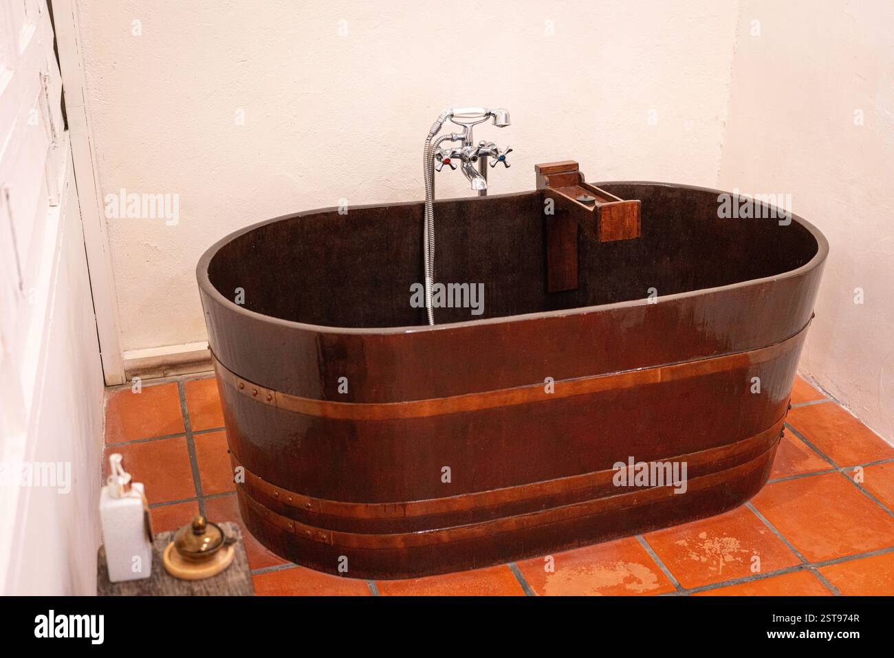 Wooden bathtub with modern shower hose inside a bathroom Stock Photo ...