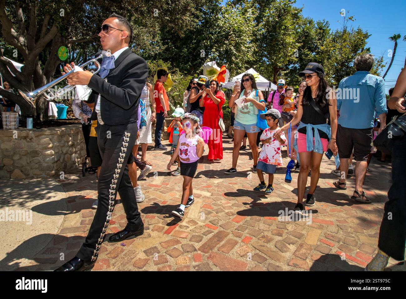 A Mexican mariachi band leads a crowd of followers at a butterfly ...