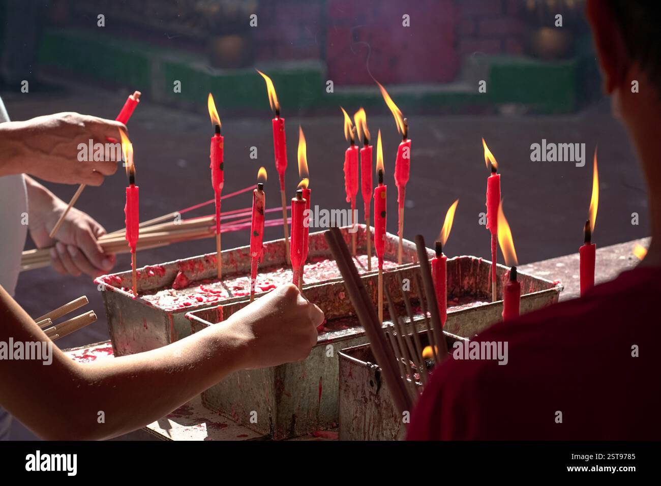 Devotee lighting candle inside a chinese taoist temple. Religion or ...