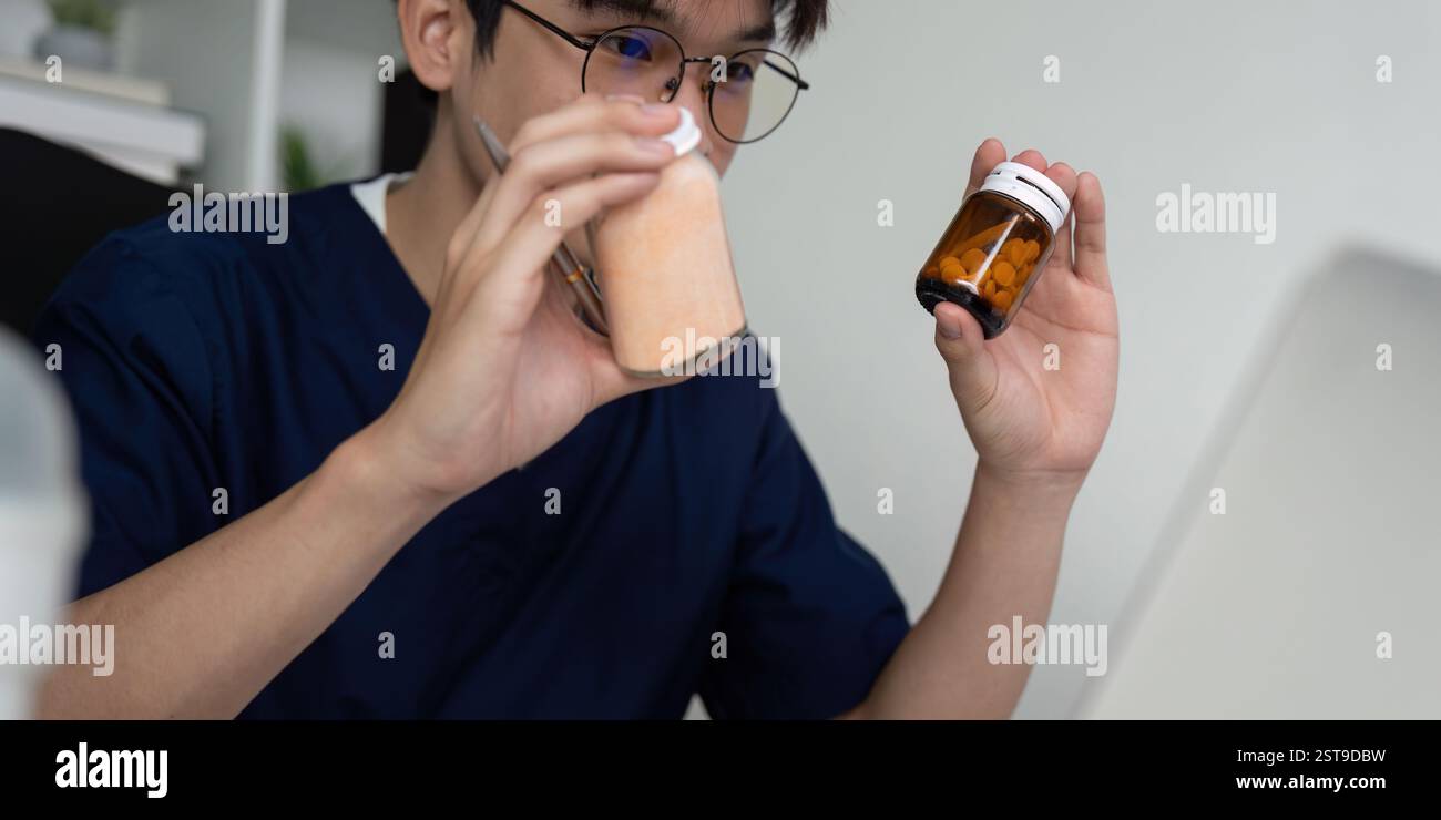 Medical student comparing medication bottles while studying online at a ...