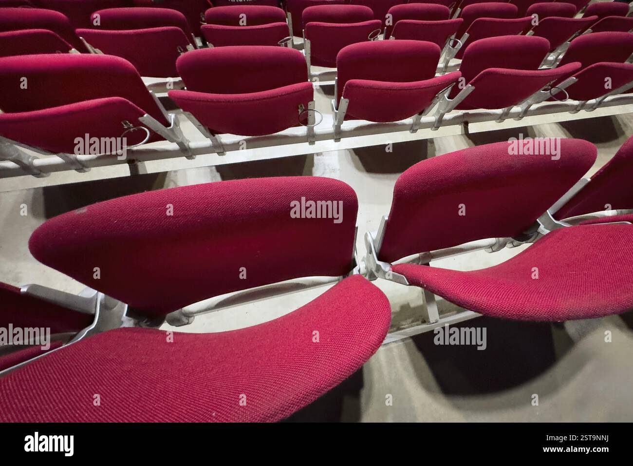 Empty folded-up seats Folding chairs with backrests in rows of seats ...