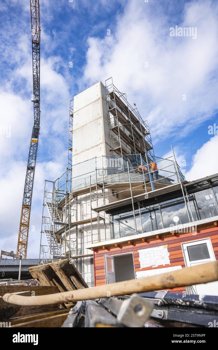 Construction site with large crane and scaffolding under a clear sky ...
