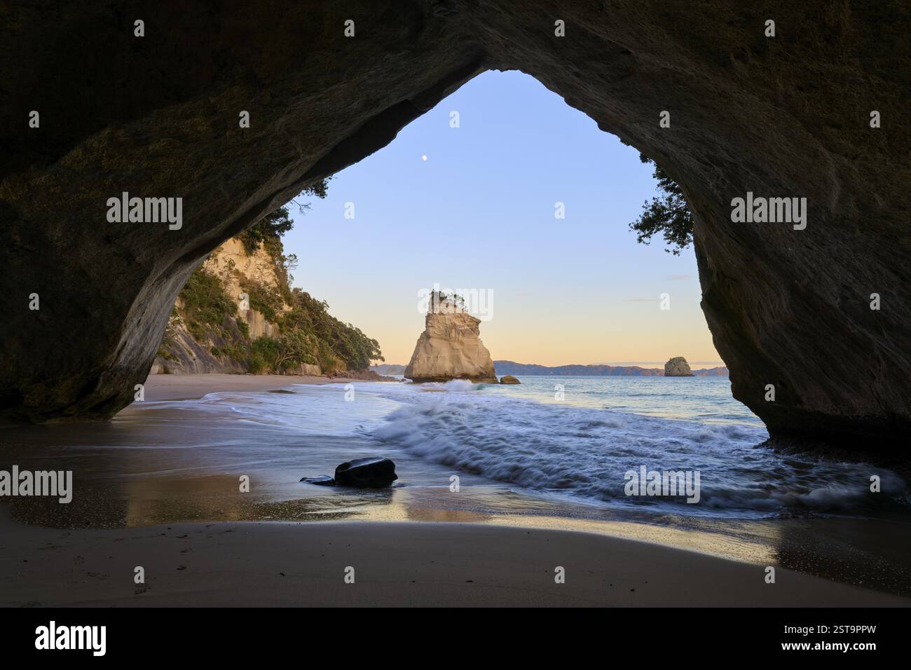 Cave opening shows a calm sea scene with rock formations in the ...