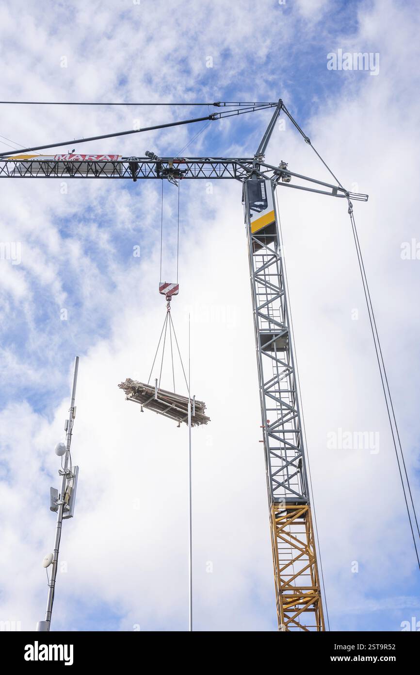 Crane lifts a heavy load under a cloudy sky, extension of the Calw ...