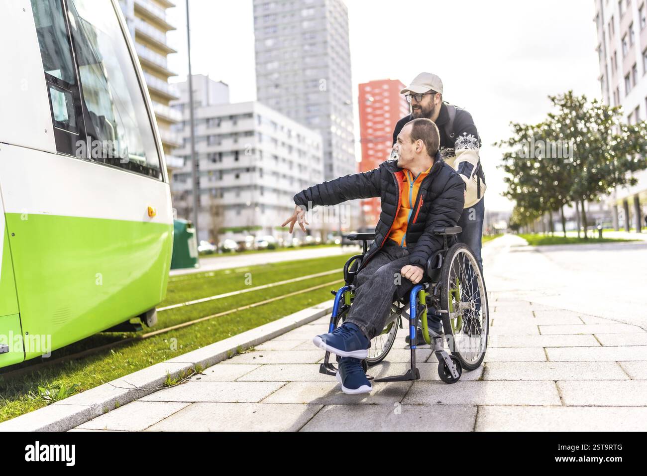 Caregiver assisting happy disabled man in wheelchair reaching out for a ...