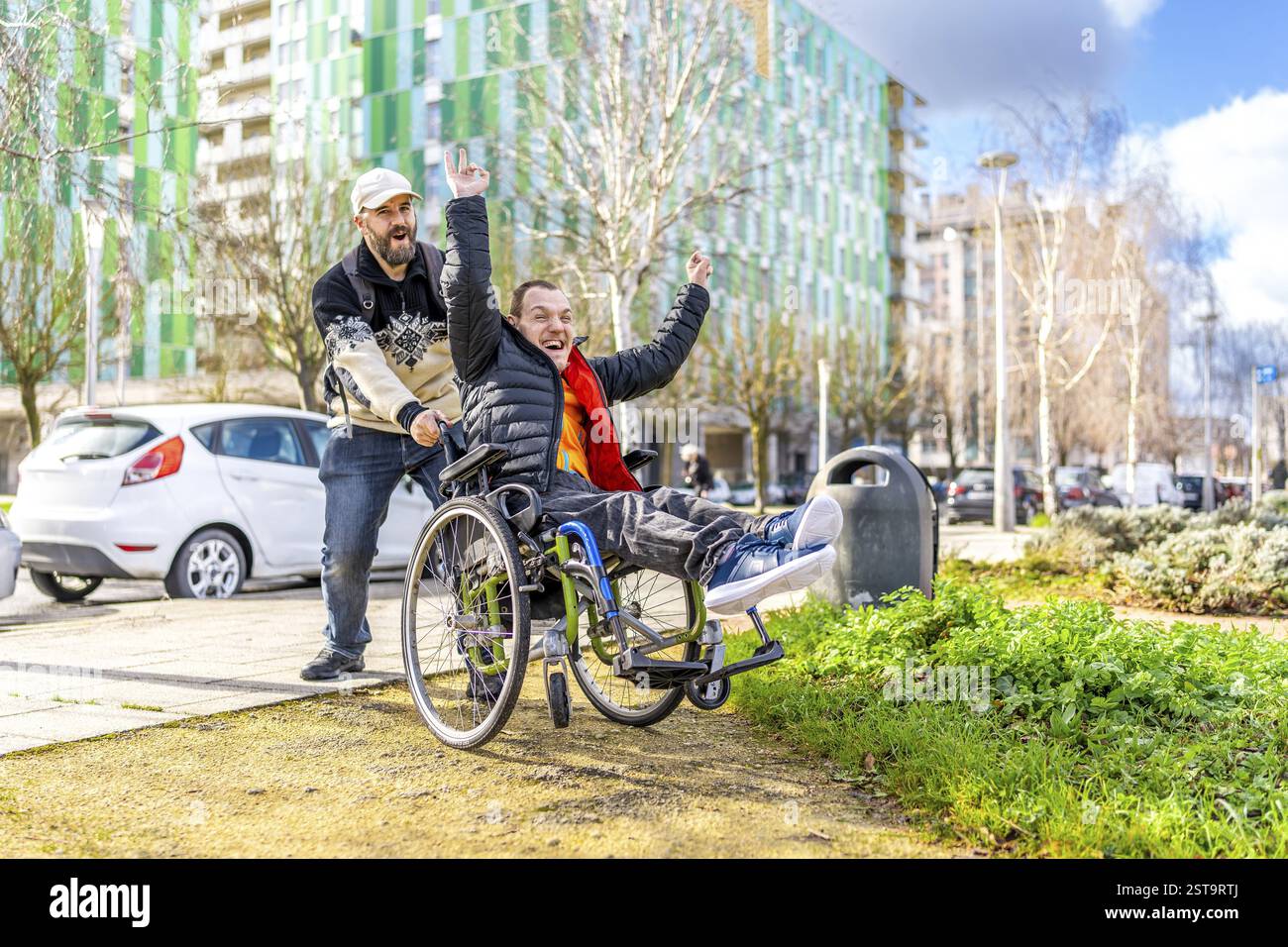 Caregiver pushing a happy disabled young man in a wheelchair having fun ...