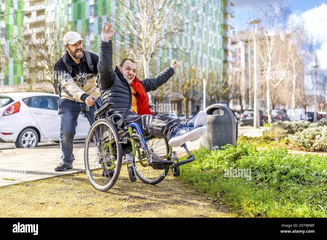 Caregiver pushing a happy disabled man in a wheelchair, enjoying a ...