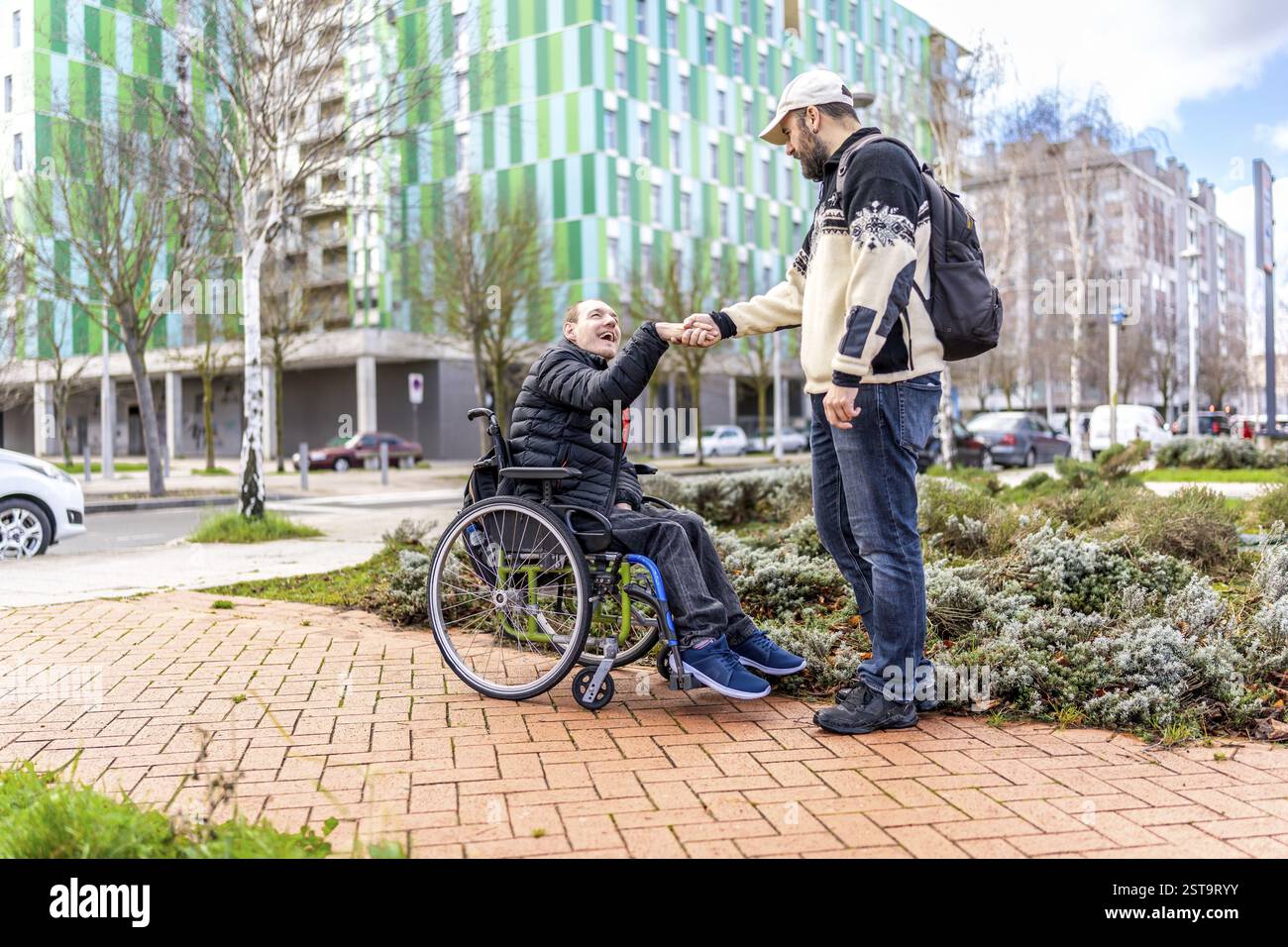 Tourist and joyful disabled man in a wheelchair sharing a fist bump on ...