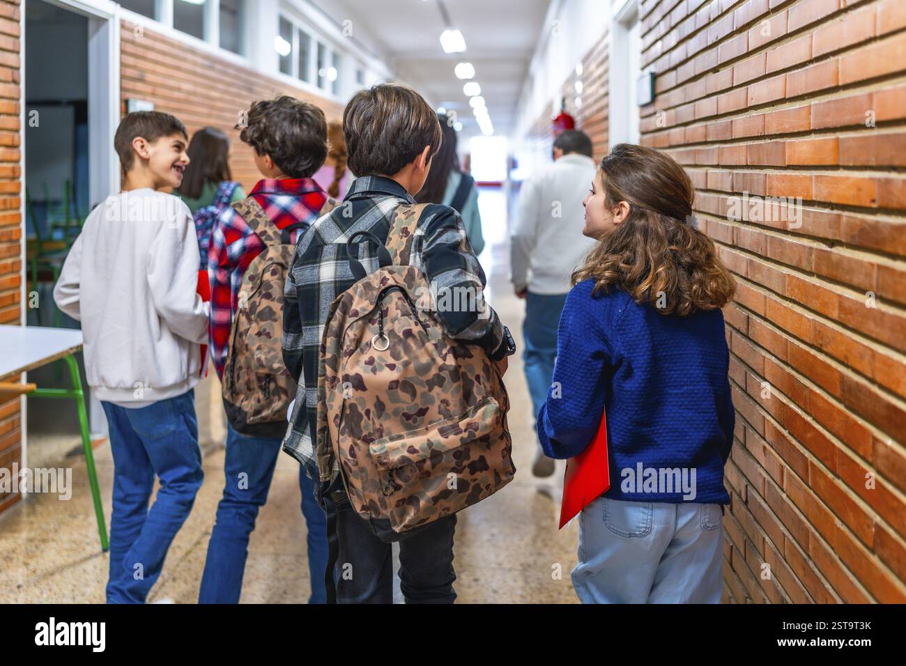 Group of elementary school students walking in the hallway between ...