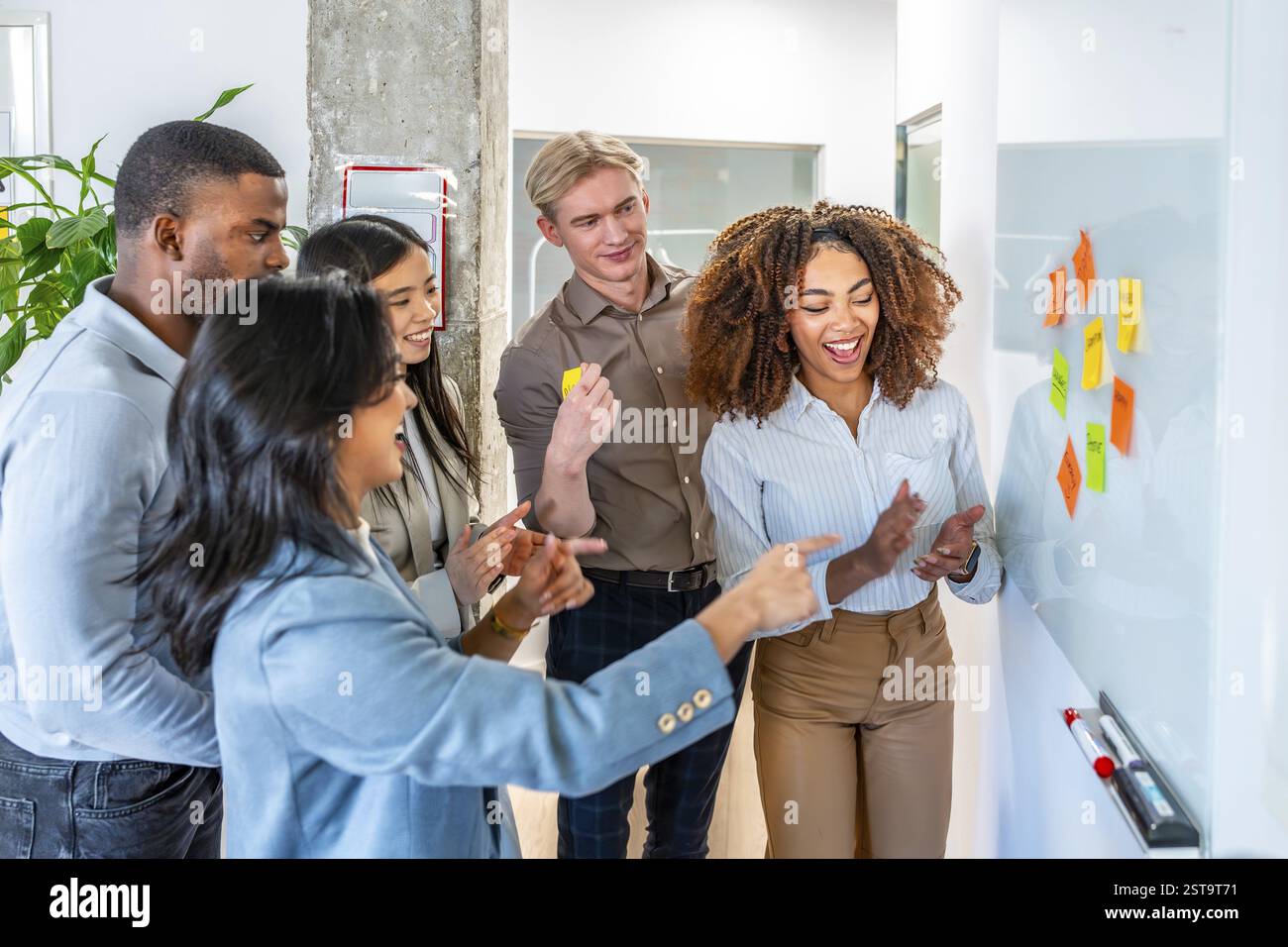 Diverse colleagues brainstorming and planning using colorful sticky ...