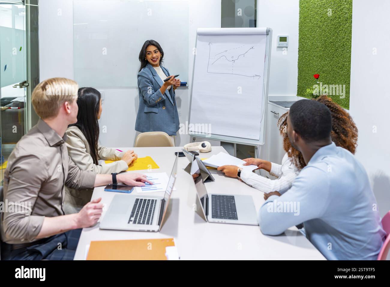 Indian businesswoman using whiteboard to explain positive data to ...