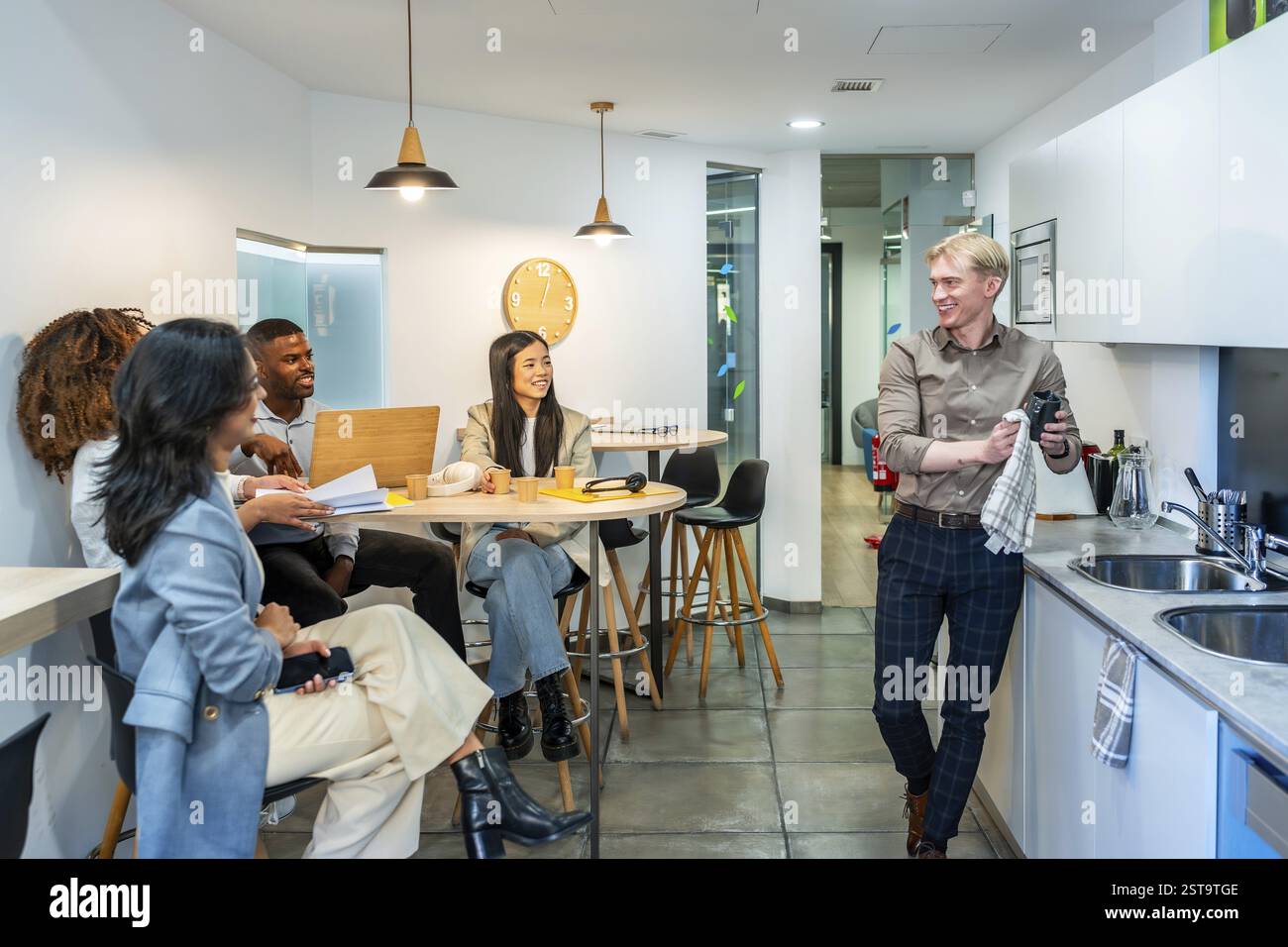 Multi ethnic colleagues enjoying coffee break, chatting and working in ...
