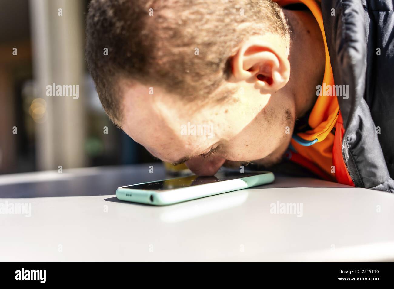 Young visually impaired man using assistive technology to interact with ...