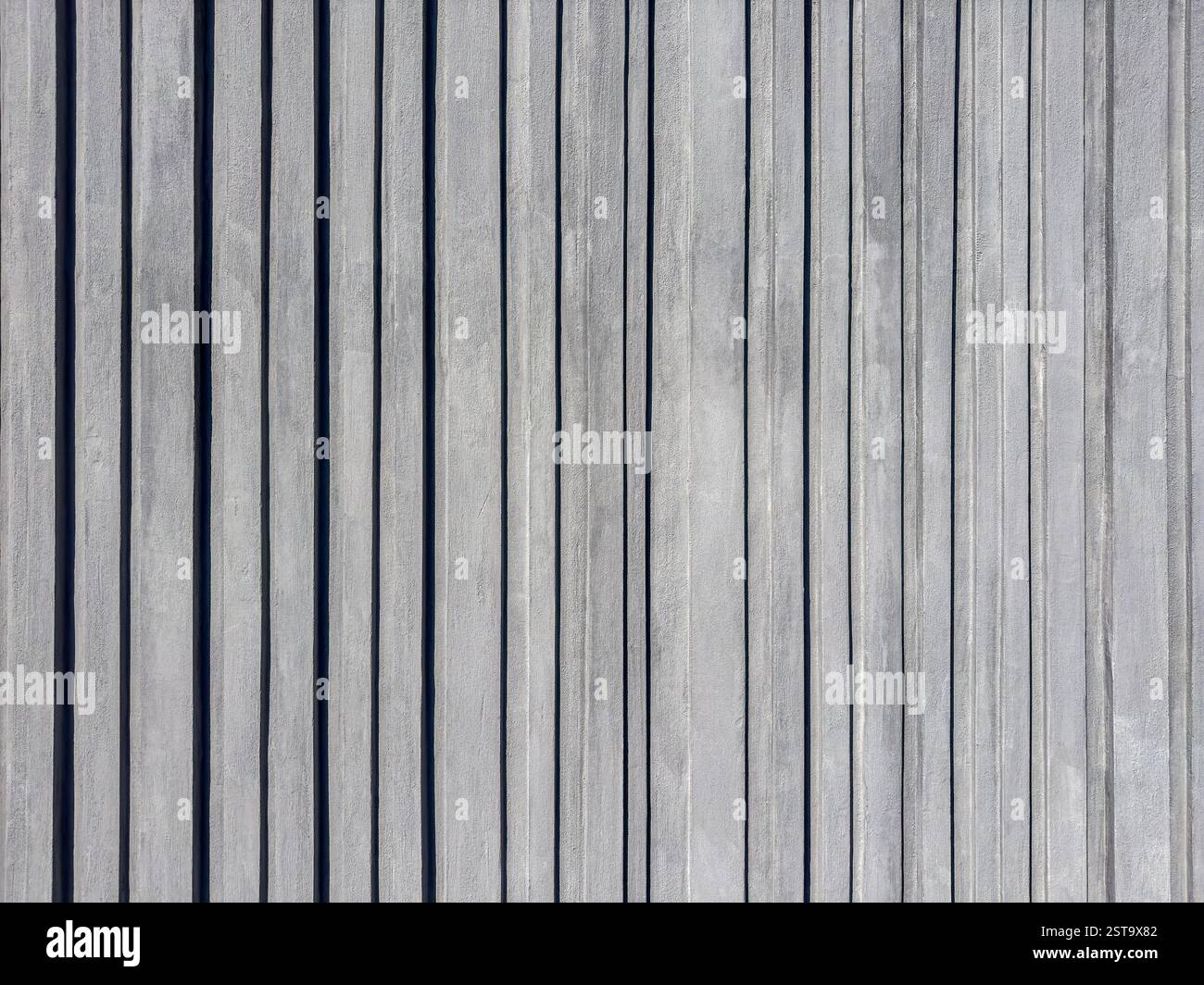 grey ribbed concrete wall with vertical stripes. rough cement plaster ...