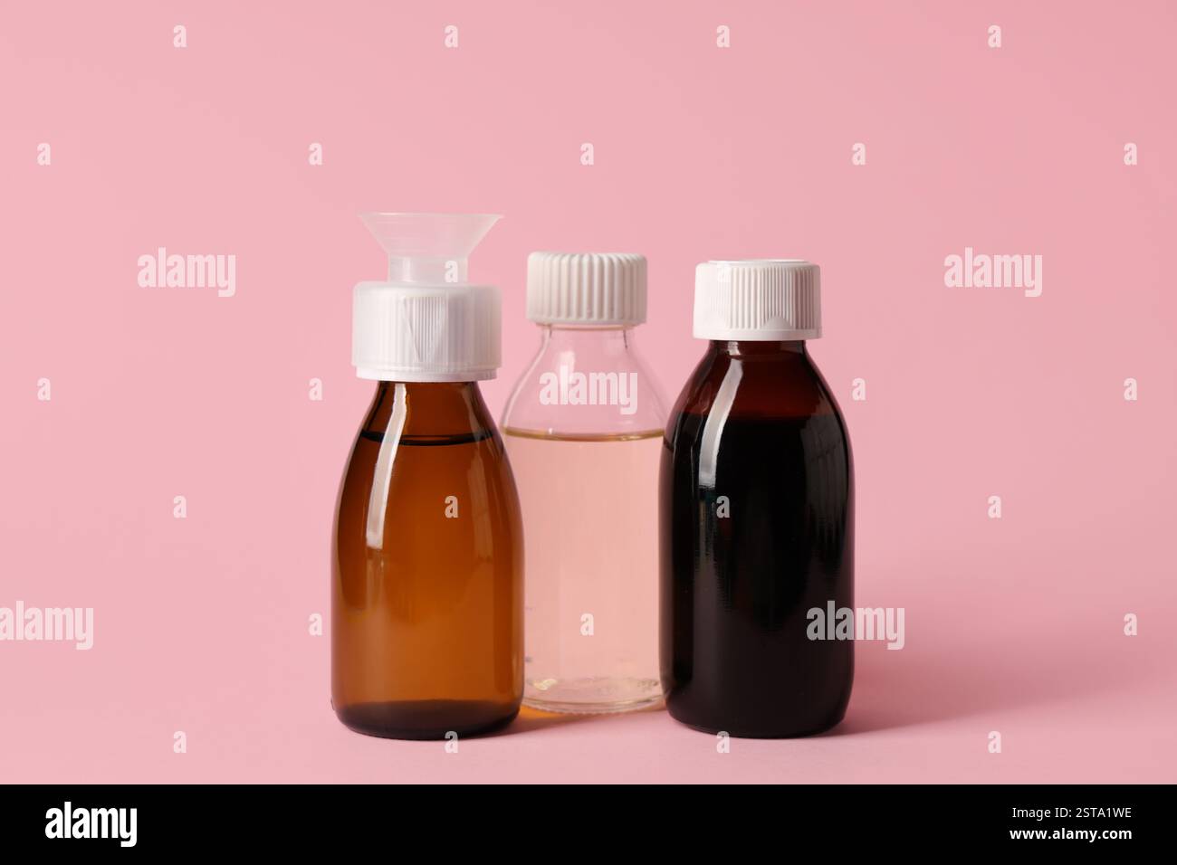 Bottles of cough syrup on pink background Stock Photo - Alamy