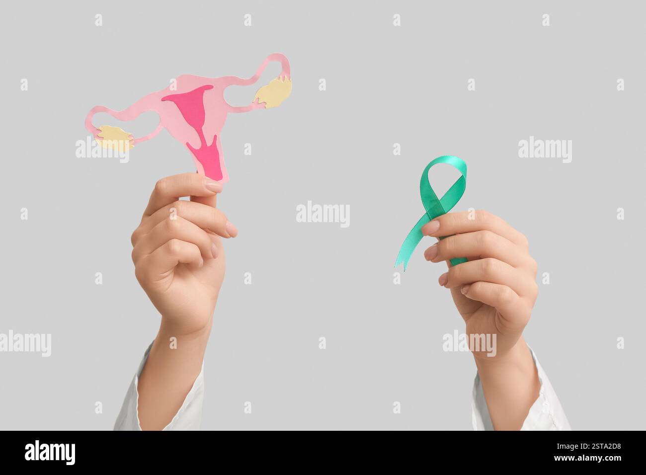 Female doctor hands with turquoise ribbon and paper uterus on white ...