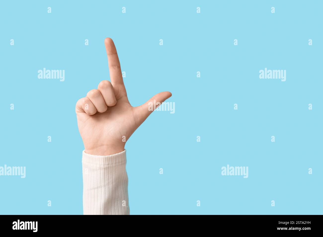 Hand showing loser gesture on blue background Stock Photo - Alamy