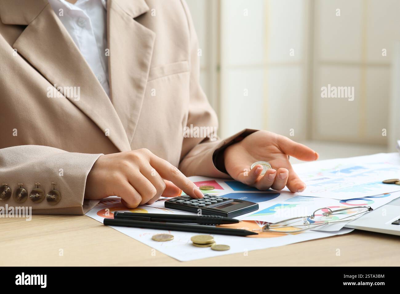 Businesswoman with coins using calculator at table, closeup. Financial ...