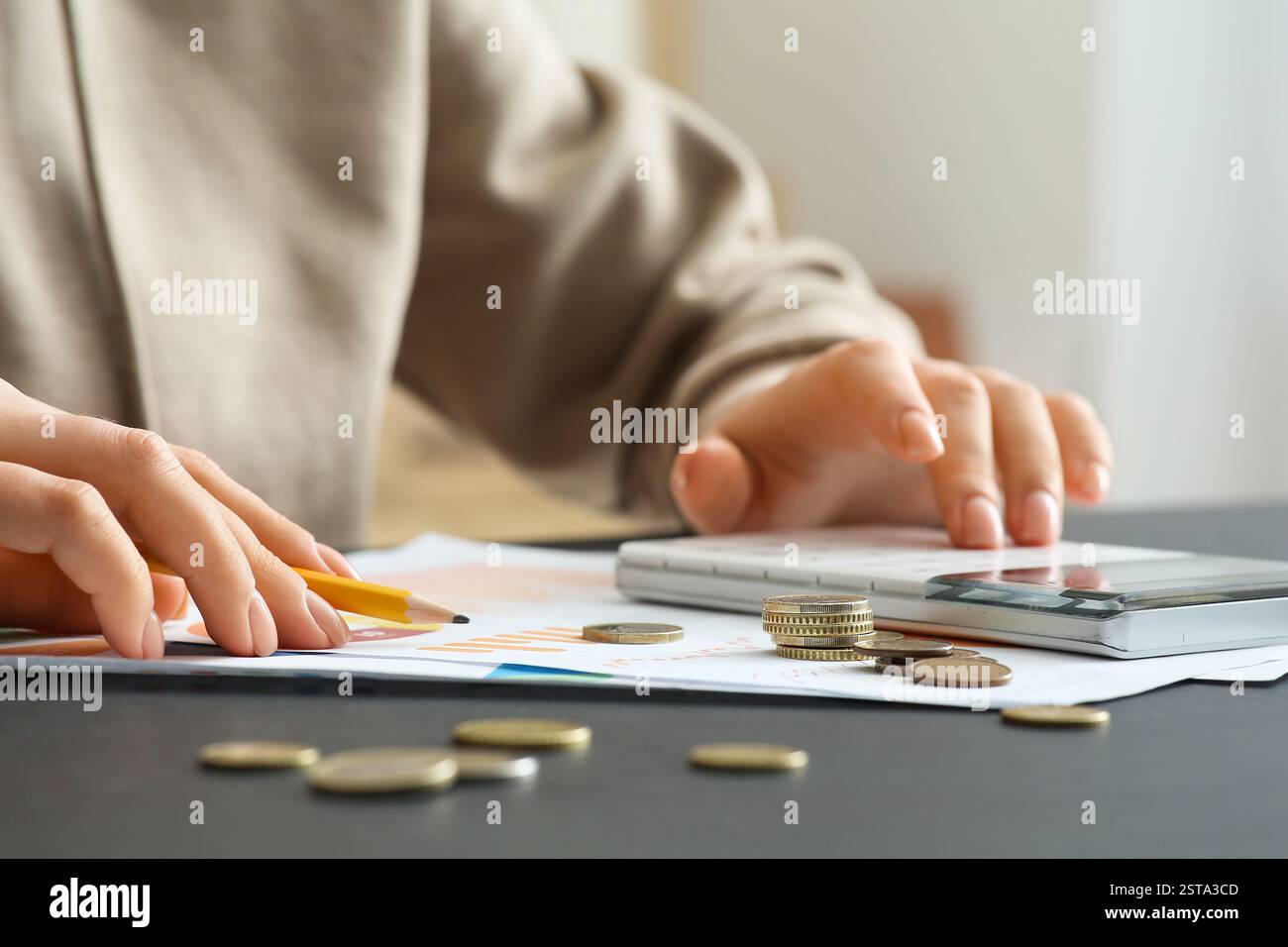 Woman with diagrams using calculator at table, closeup. Financial ...