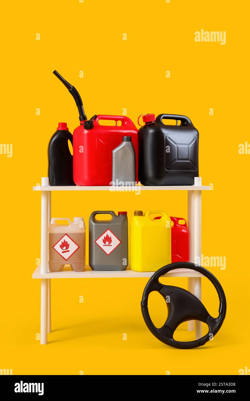Shelf unit with canisters and car steering wheel on yellow background ...