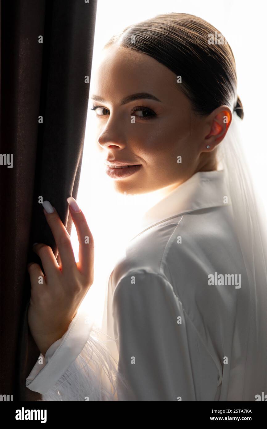 Back view of bride wearing white suit and veil standing between ...