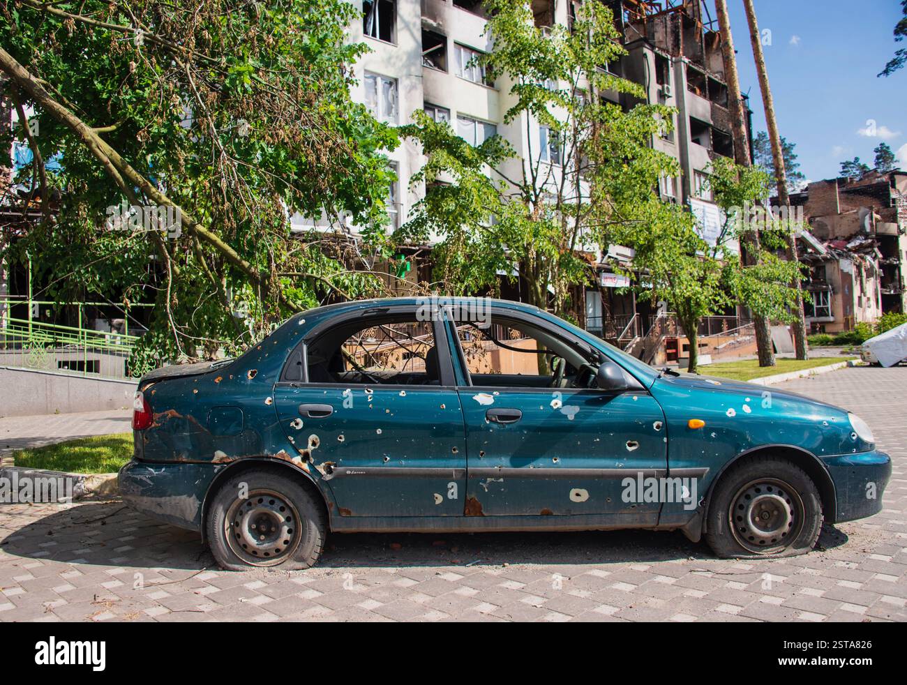 A bullet-riddled vehicle sits outside a devastated apartment block in ...
