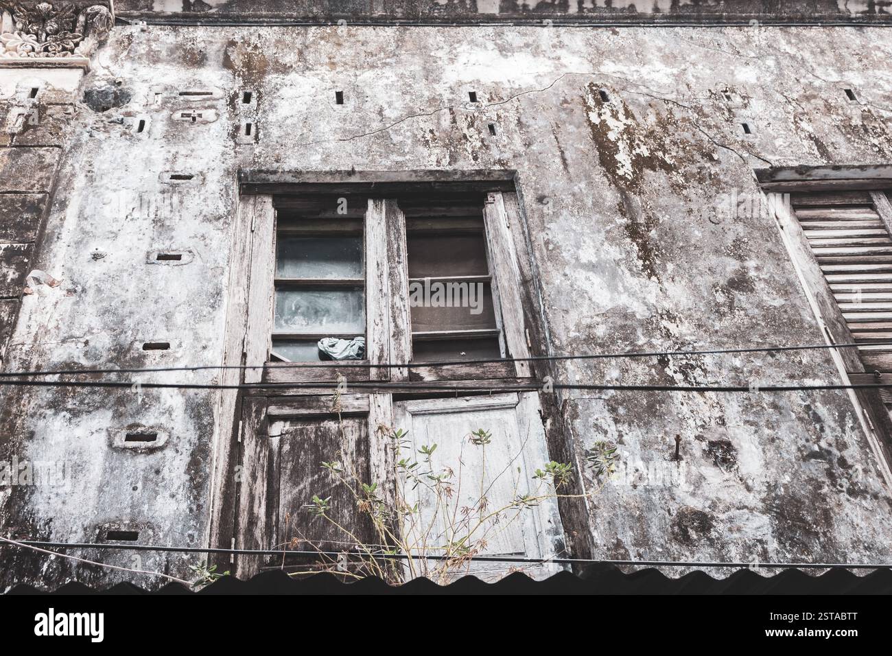 Aged building with dirty walls and broken window in Stone Town ...