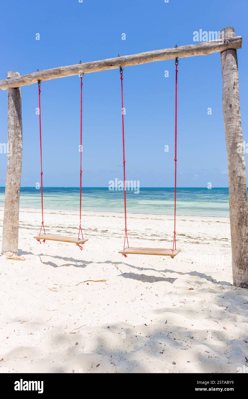 Wooden swing on the beach. Swing with two seats on scenic seascape. Idyllic exotic resort ...