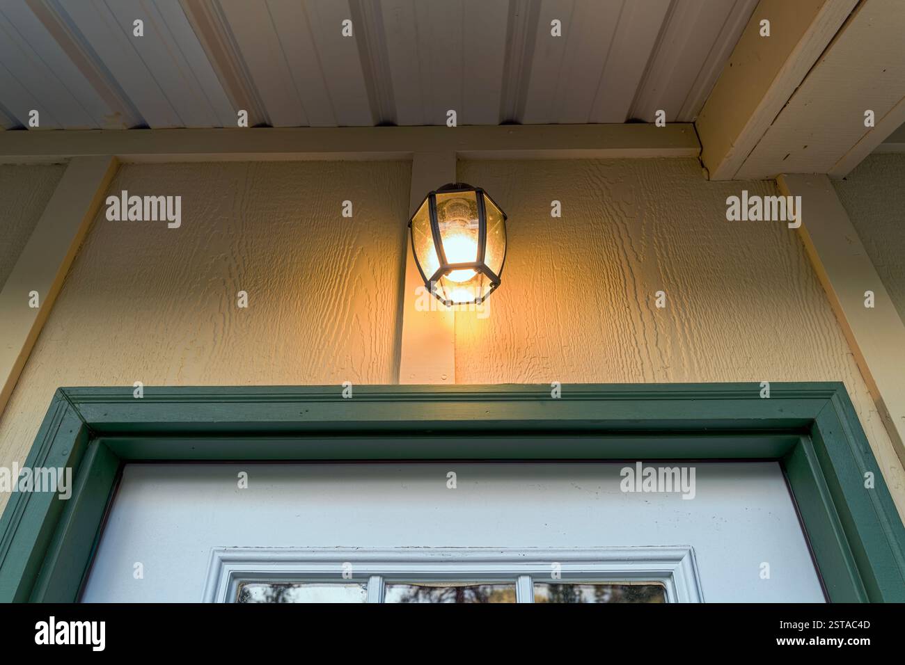 Illuminated electric light fixture above an exterior door Stock Photo ...