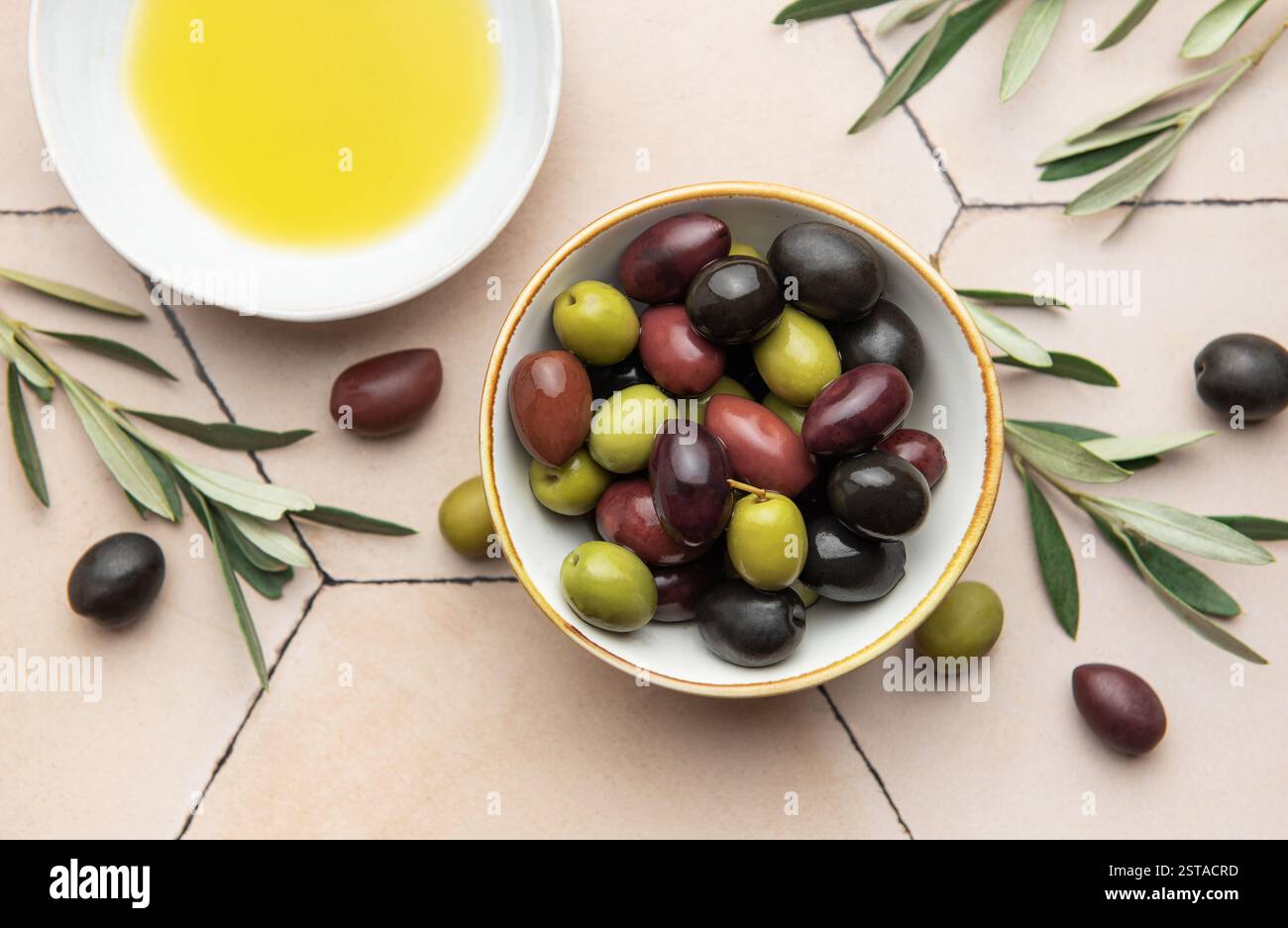 Colorful olives, olive oil, and olive branches create a mediterranean ...