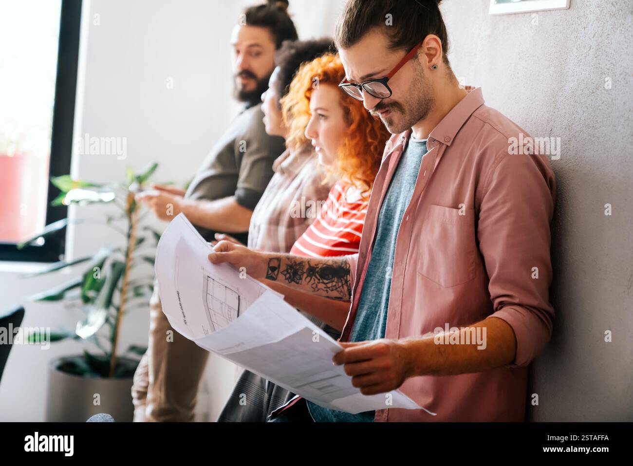 Happy businesspeople laughing while collaborating on a new project in ...