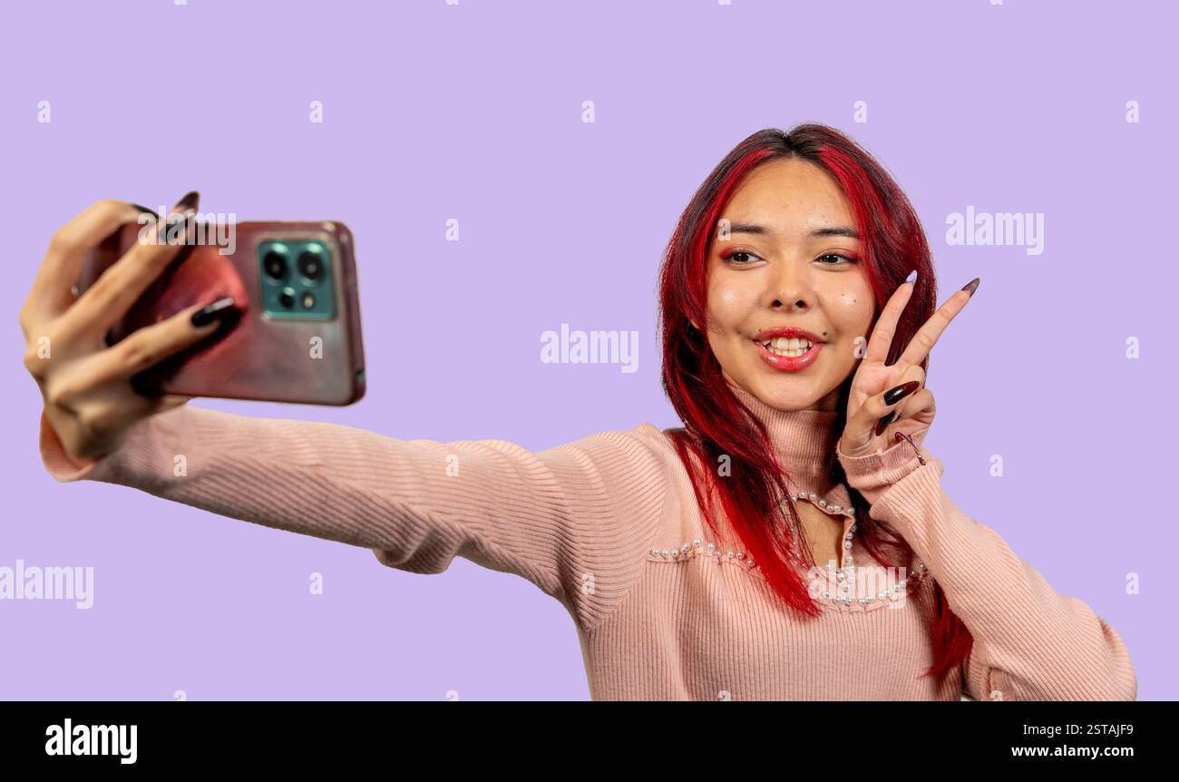 Smiling influencer showing peace sign while taking a selfie with ...