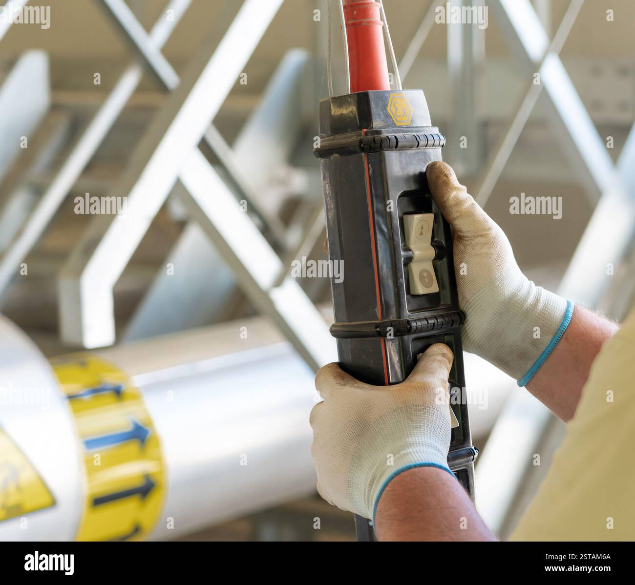 Operator controlling a hoist crane with a handheld control panel in an ...