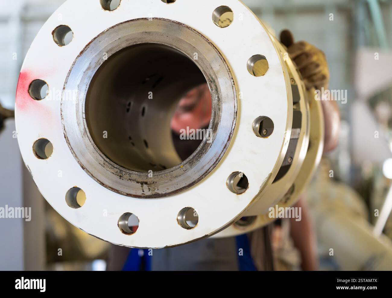 Ultrasonic flow meter with flanged connection held by a worker during ...