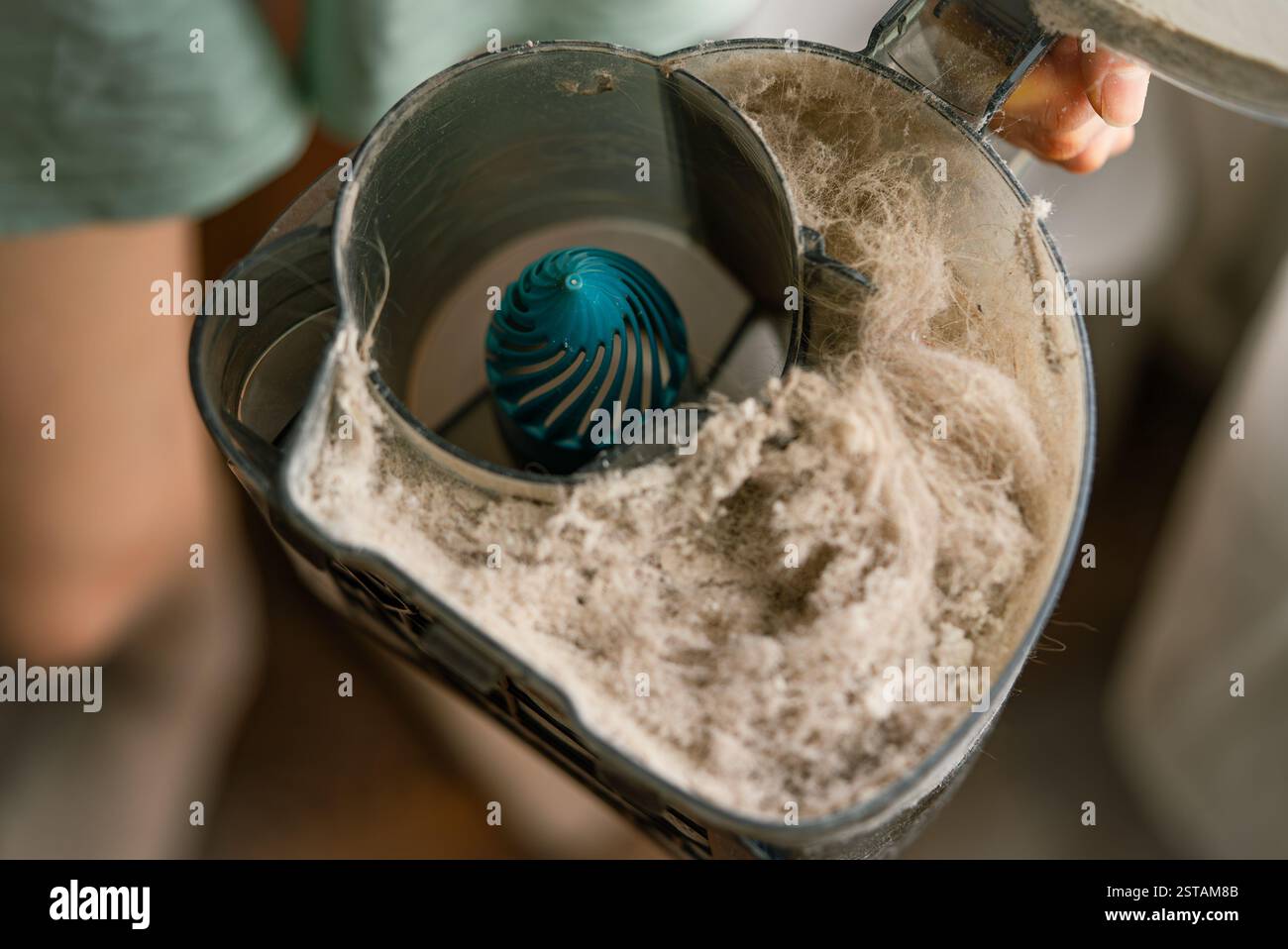 Housekeeper holding a full dust container, emphasizing the significance ...