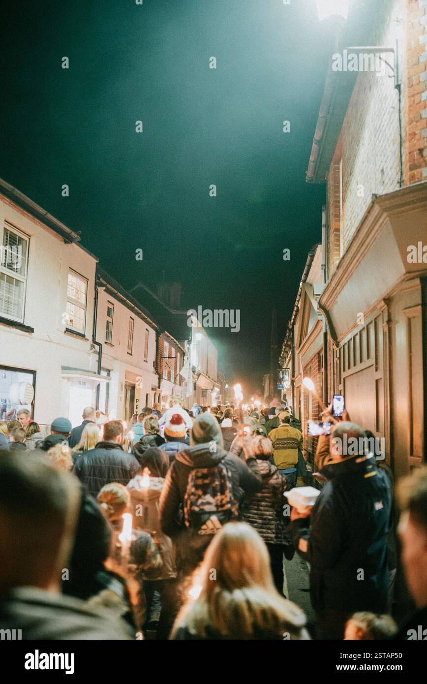A large crowd of people are gathered on a street, some of them holding ...