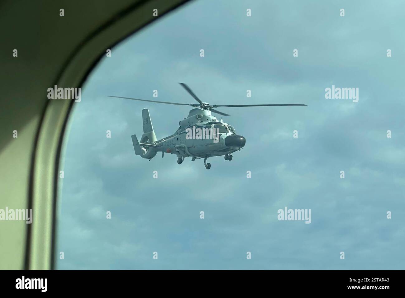 A Chinese military helicopter flies close to a Philippine Bureau of ...