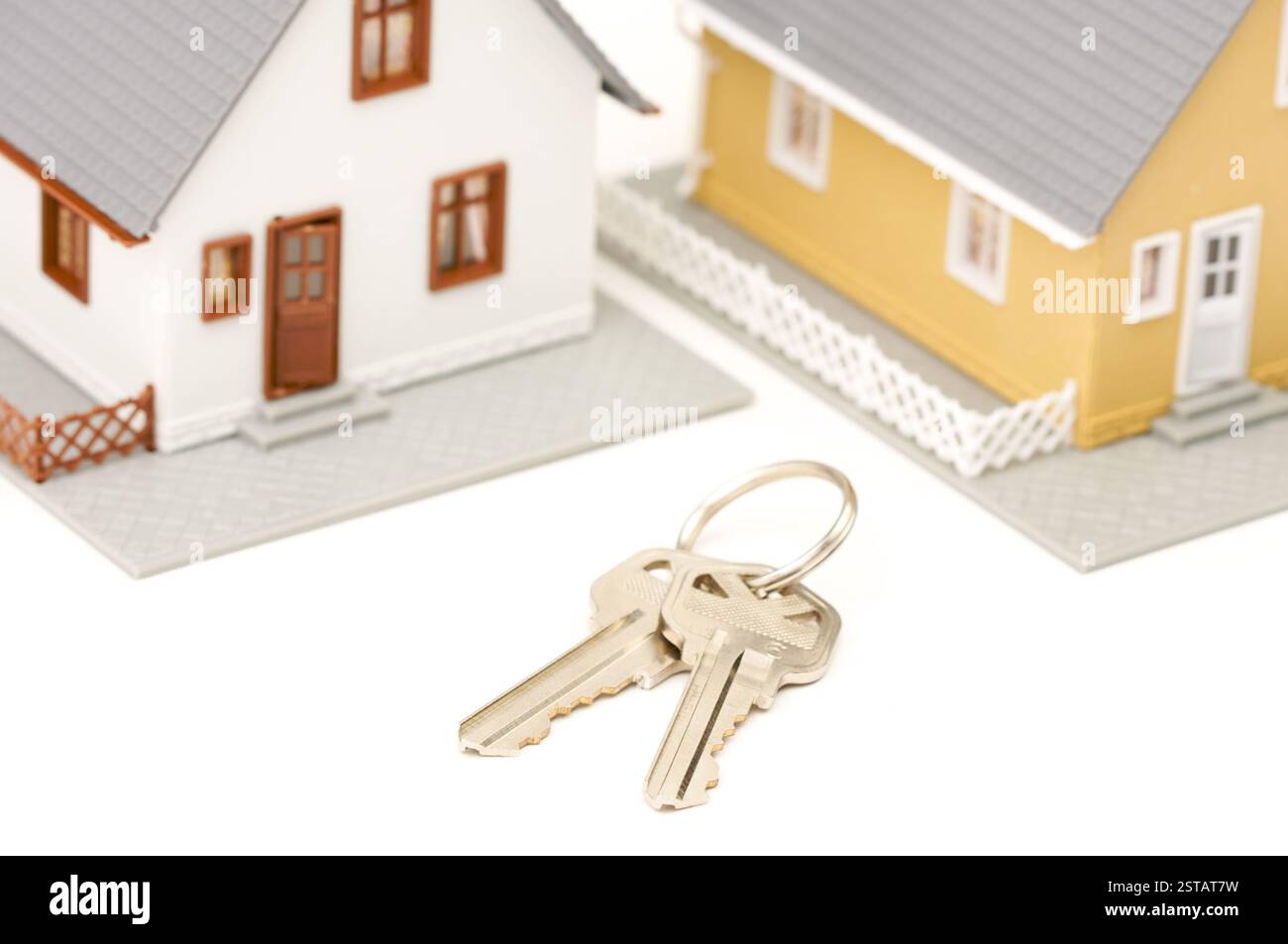 Keys and Houses isolated on a white background. Focus is on the keys ...