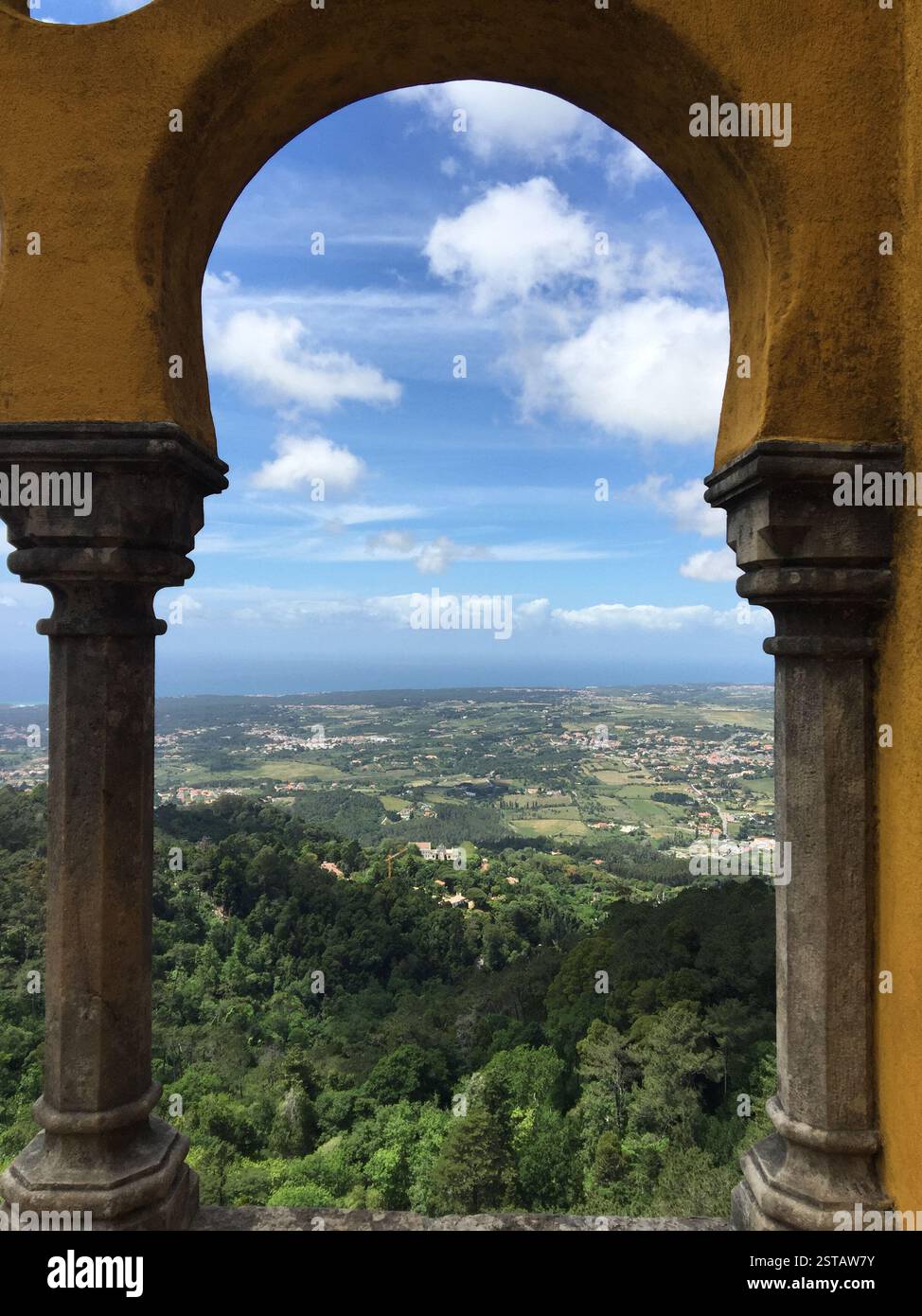 Pena Palace. Arched window frames a sweeping vista of verdant hills ...