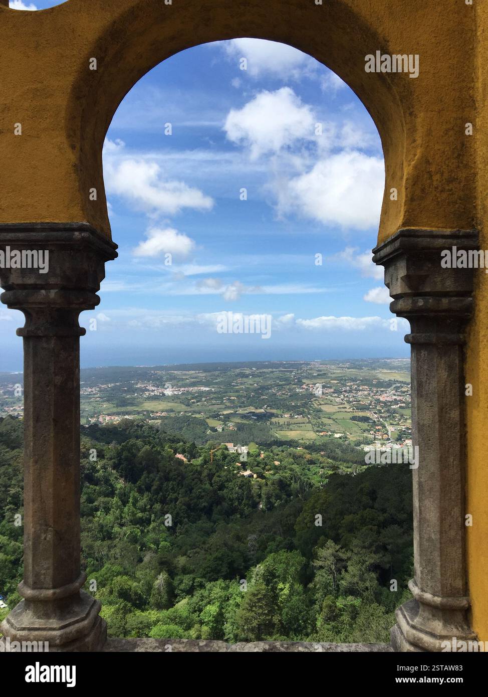 Pena Palace. Arched window frames a sweeping vista of verdant hills ...