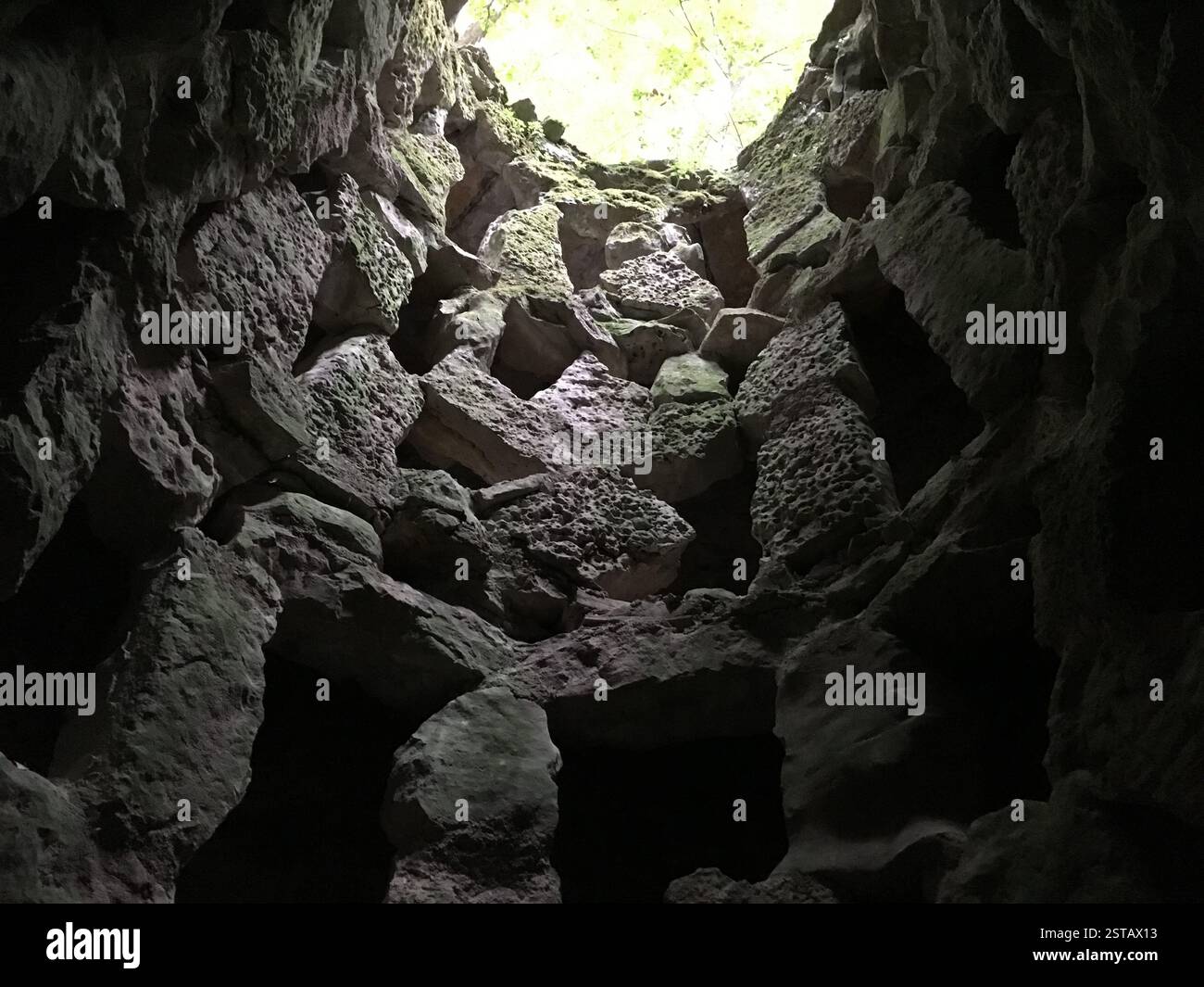 Vertical shaft, jagged rock formations illuminated by sunlight. Symbol ...