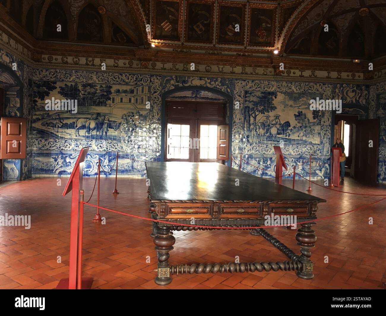 The ornate wooden table dominates the room, surrounded by blue and ...