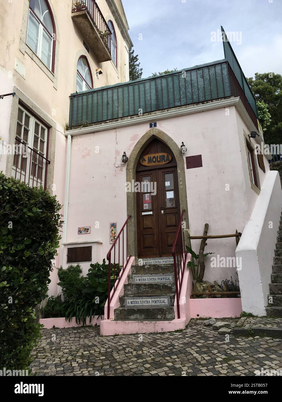 Sintra, Portugal. Pink stucco building facade. Arched doorway, brown ...