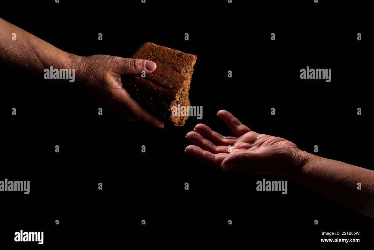 Elder woman hand give a loaf of bread to hands of a beggar. Poverty and ...