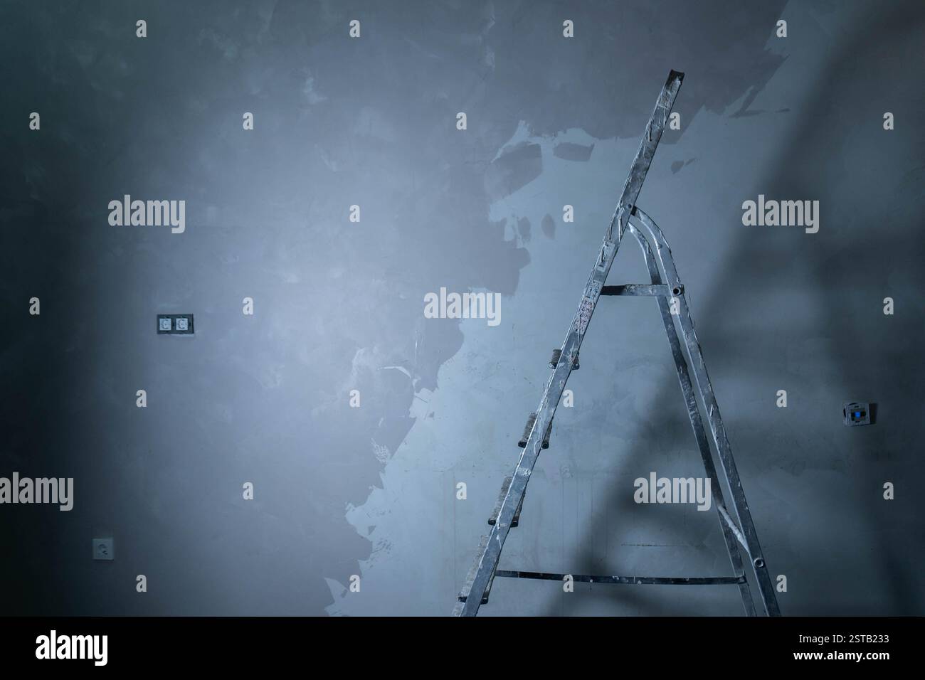 Ladder stands beside wall as epoxy adhesive is applied to repair ...