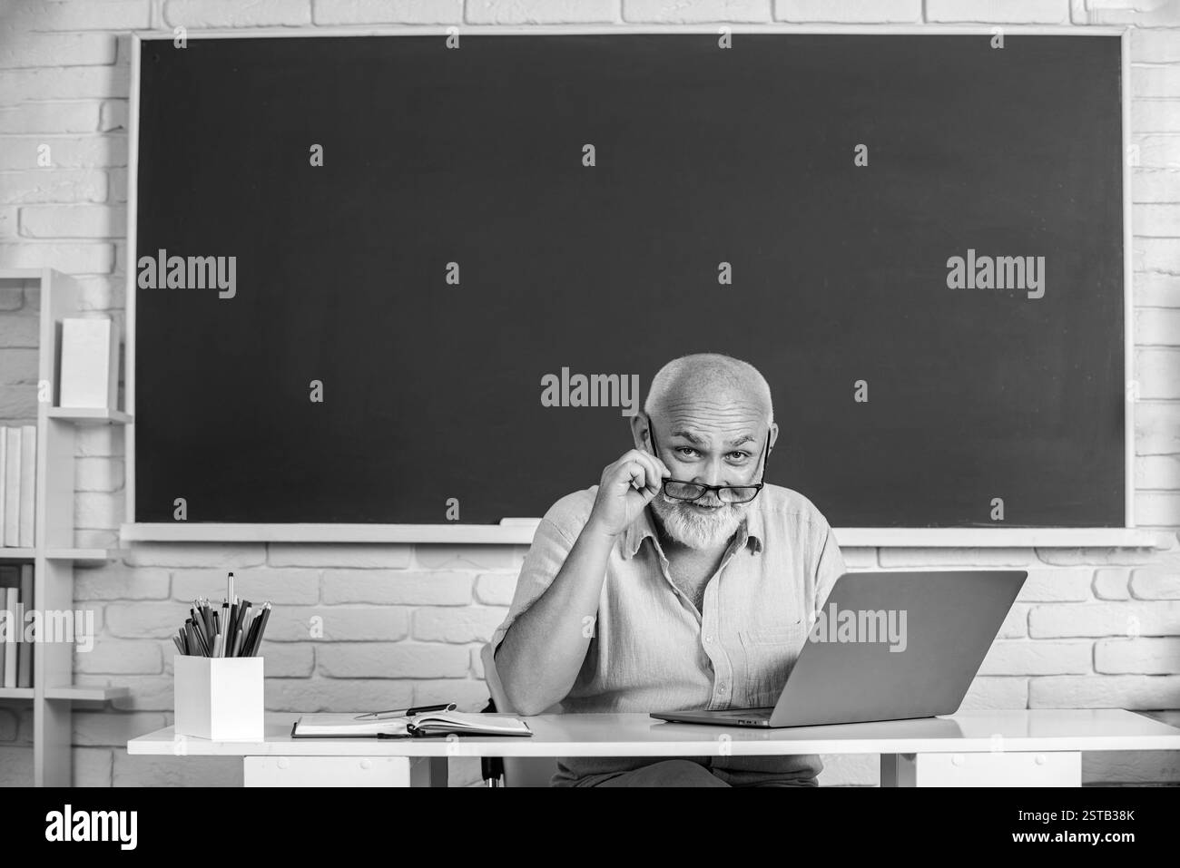 Working as teacher smiling. Male teacher in his classroom. Smiling man ...