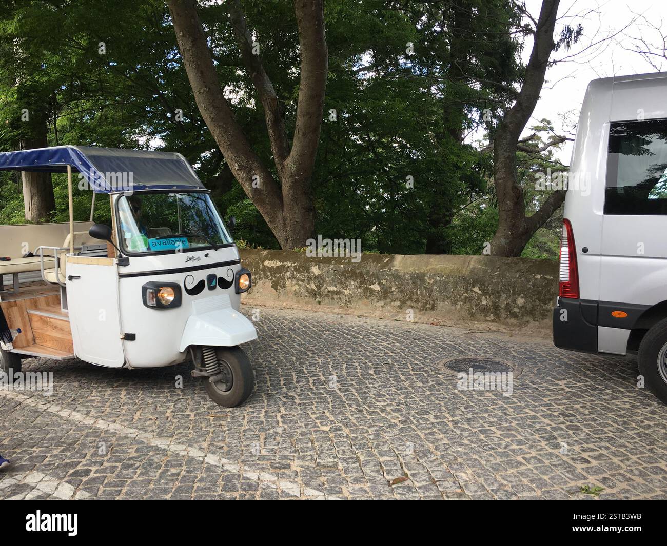 Tuk Tuk driving on cobblestone street in Sintra, Portugal. Tuk Tuks are ...