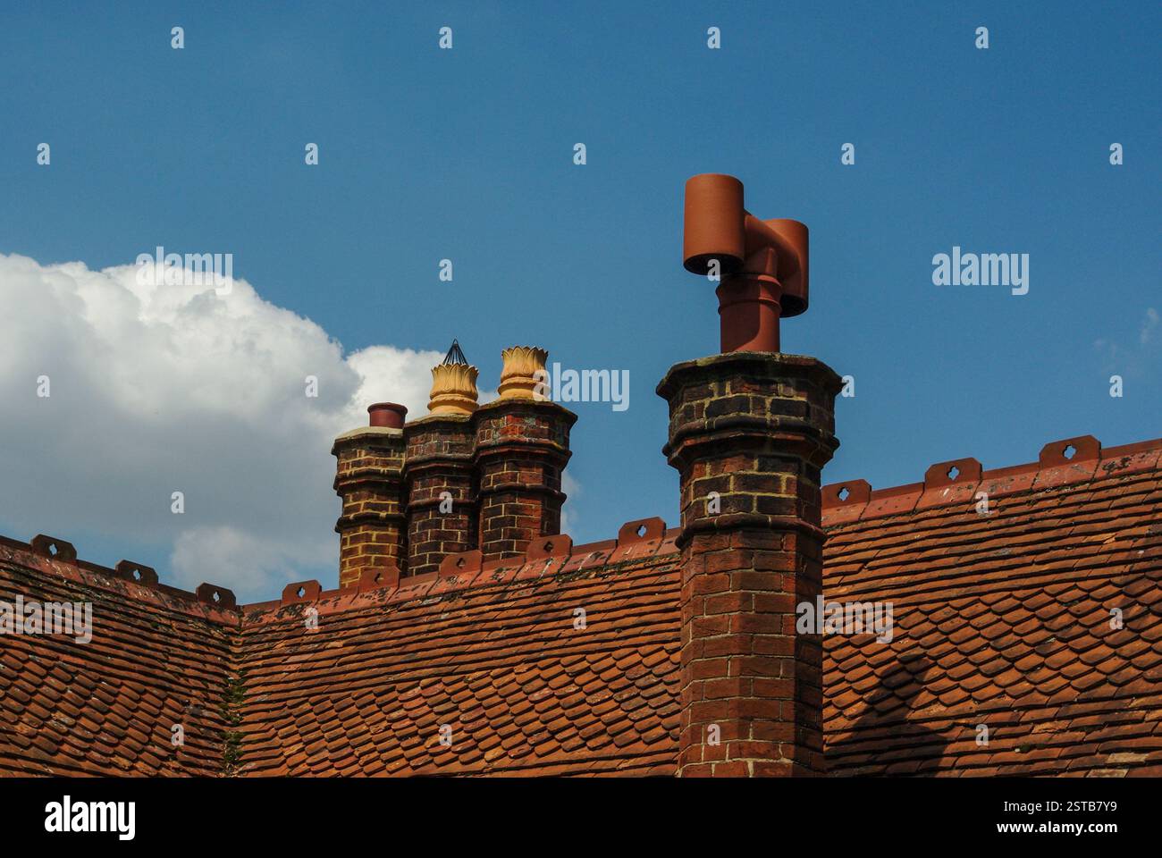 Ornate brick chimneys on a red tiled roof, probably late 19th century ...