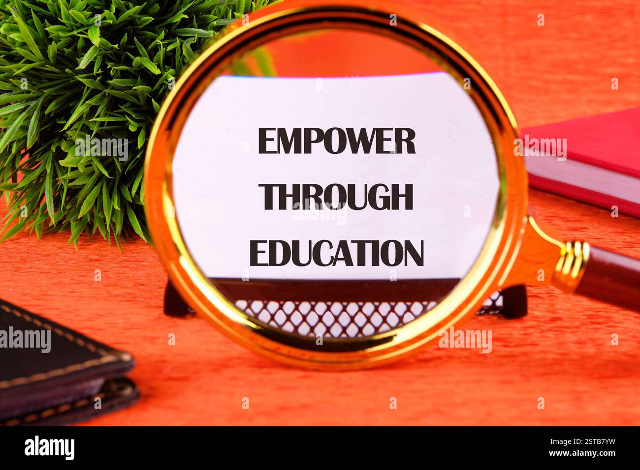 A magnifying glass focuses on the words Empower Through Education ...