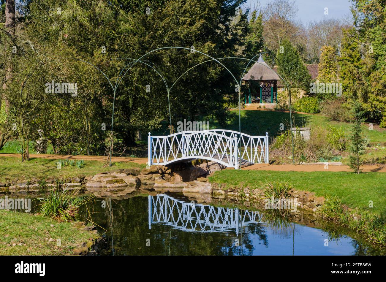 A blue cast iron bridge in the woodland area of the Swiss Garden, Old ...